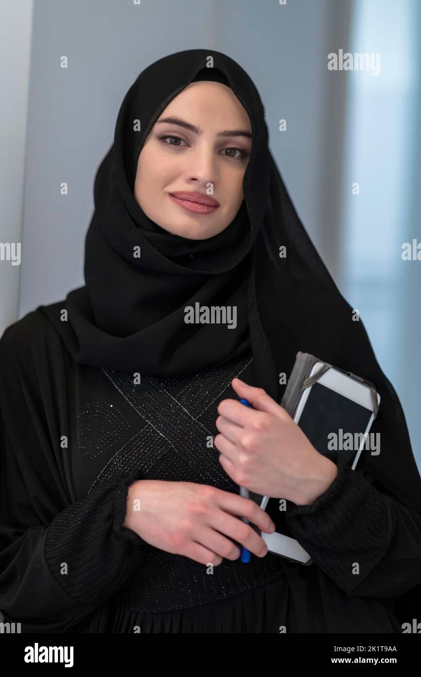 Young modern muslim business woman using smartphone wearing traditional ...
