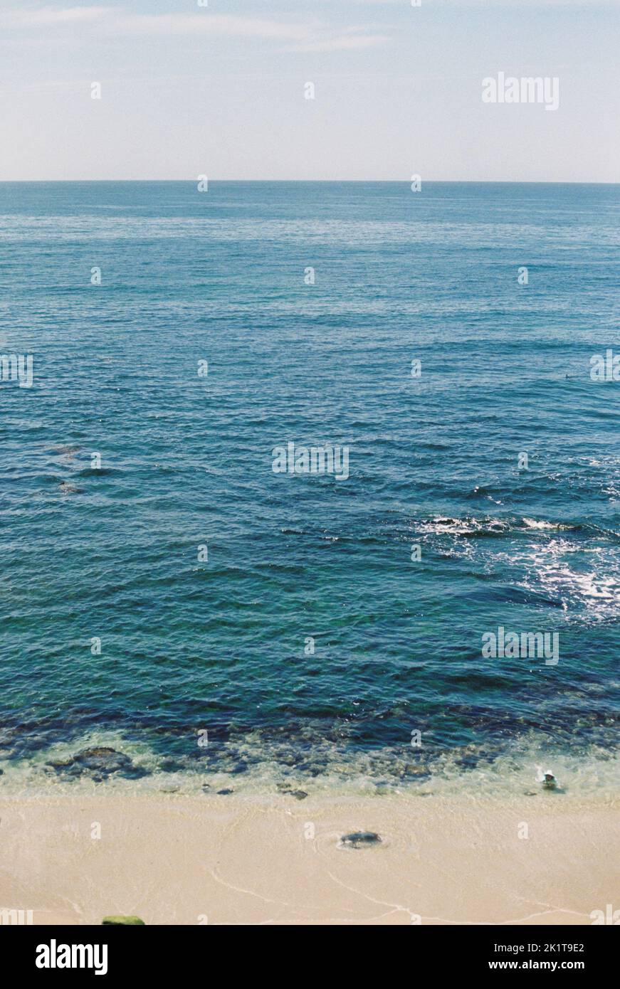 A vertical shot of tranquil sea waves hitting a sandy shore Stock Photo ...
