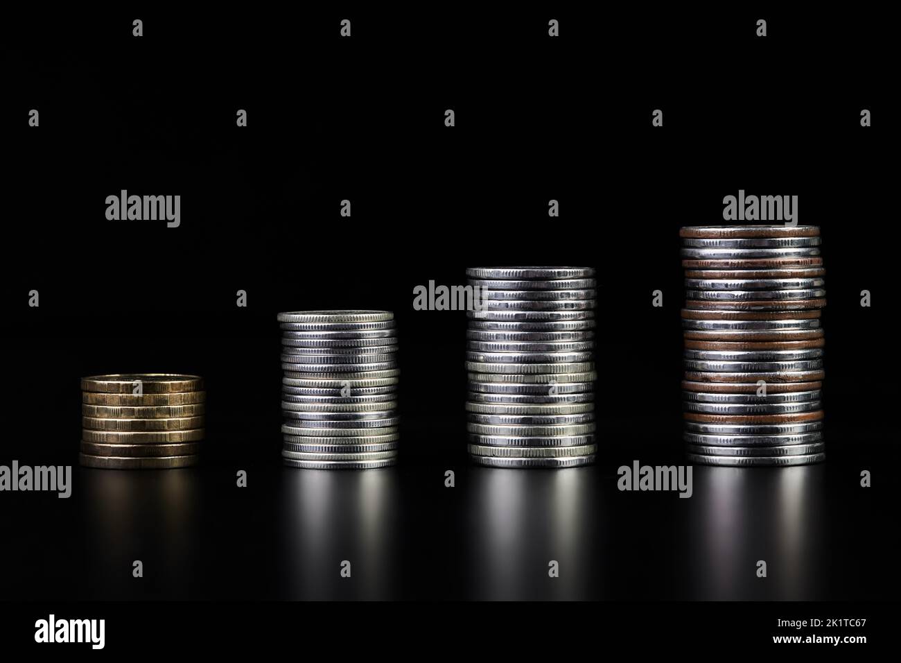 Stacks of metallic coins on a dark background Stock Photo - Alamy