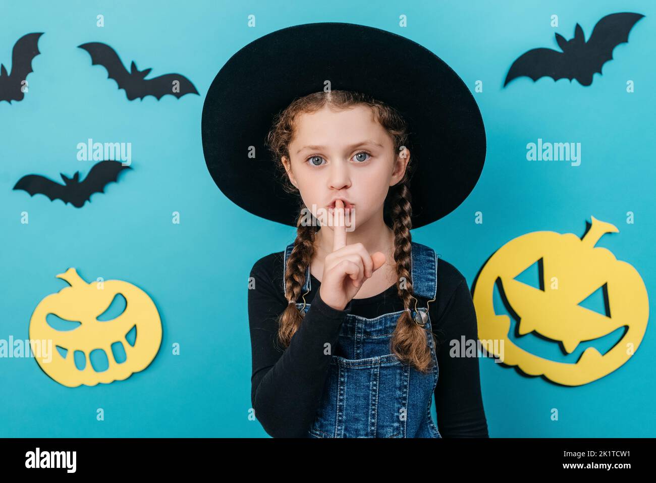 Stupefied little girl child in hat makes gesture quietly, asks remain ...