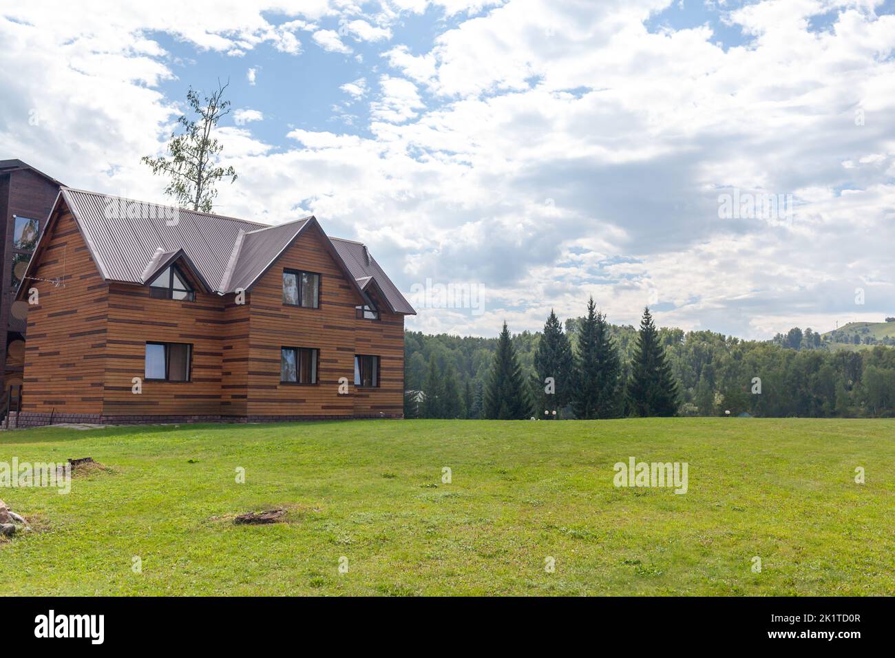 Two-storey wooden cottage with windows nature with a green lawn Stock ...