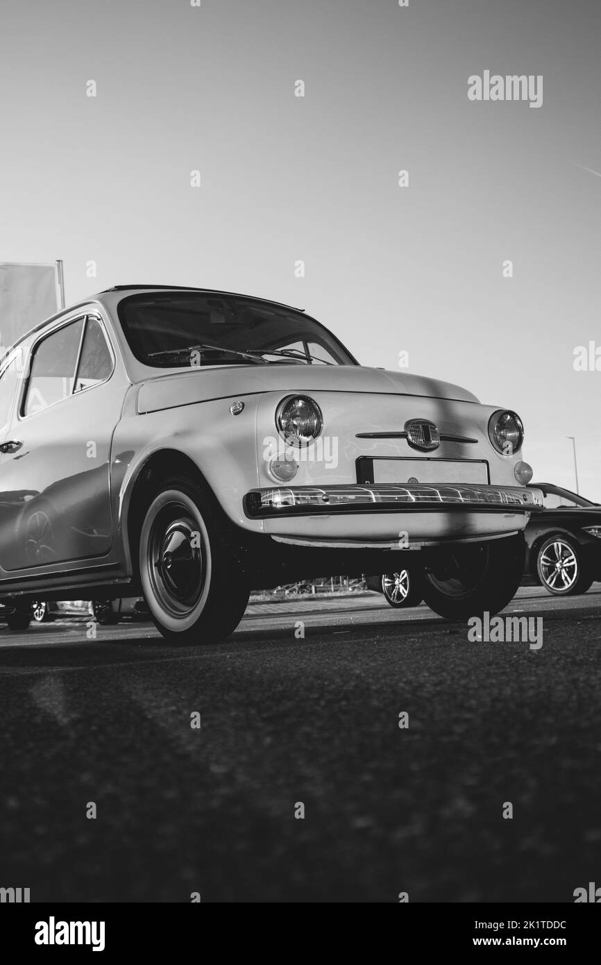 A vertical grayscale of a vintage car parked in a parking lot Stock ...