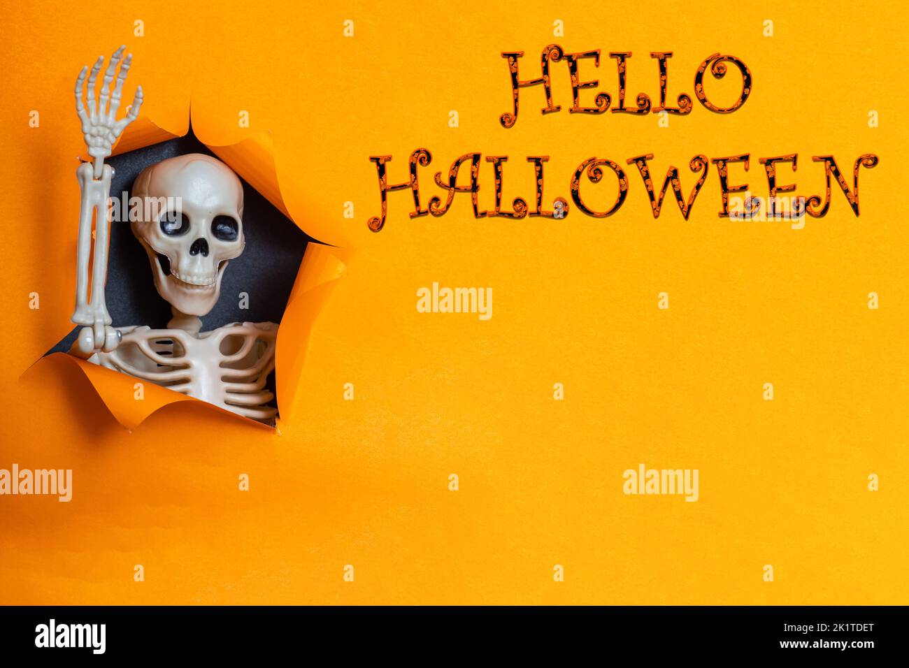 Happy Halloween. A cute little toy Skeleton waves its bony arms through ...