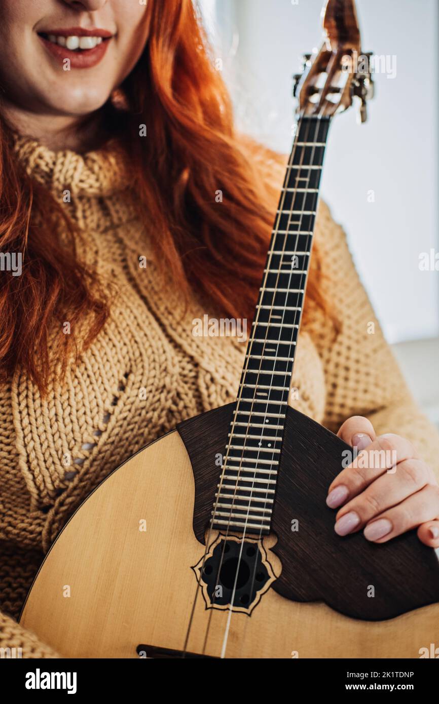 Domra Folk Musical Instrument in womans hand. Female hands with 4 ...