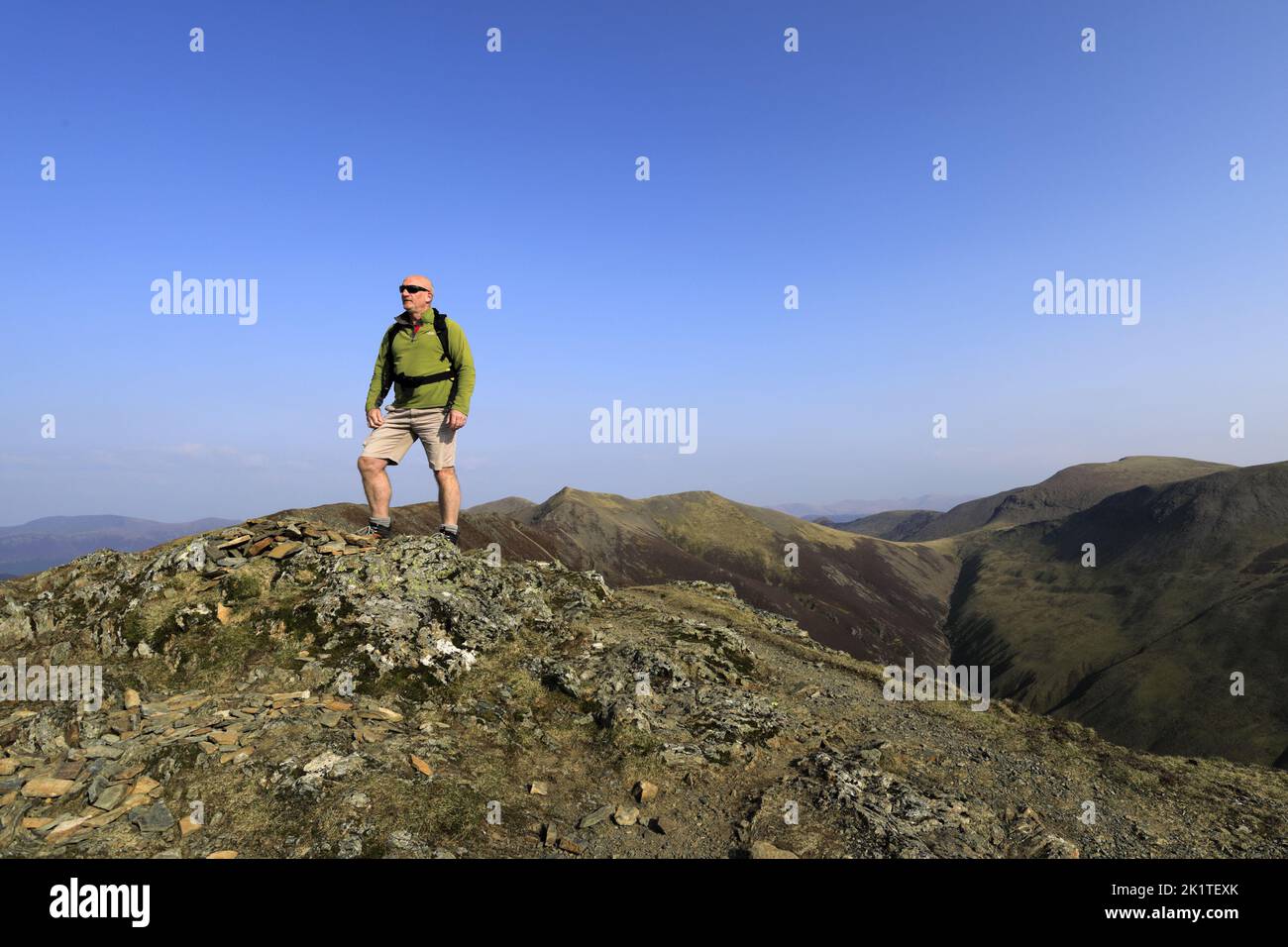Walker at the summit cairn of Whiteside fell, Lake District National ...
