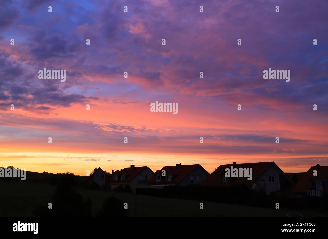 Mody dark sunset sky in a rural landscape Stock Photo - Alamy
