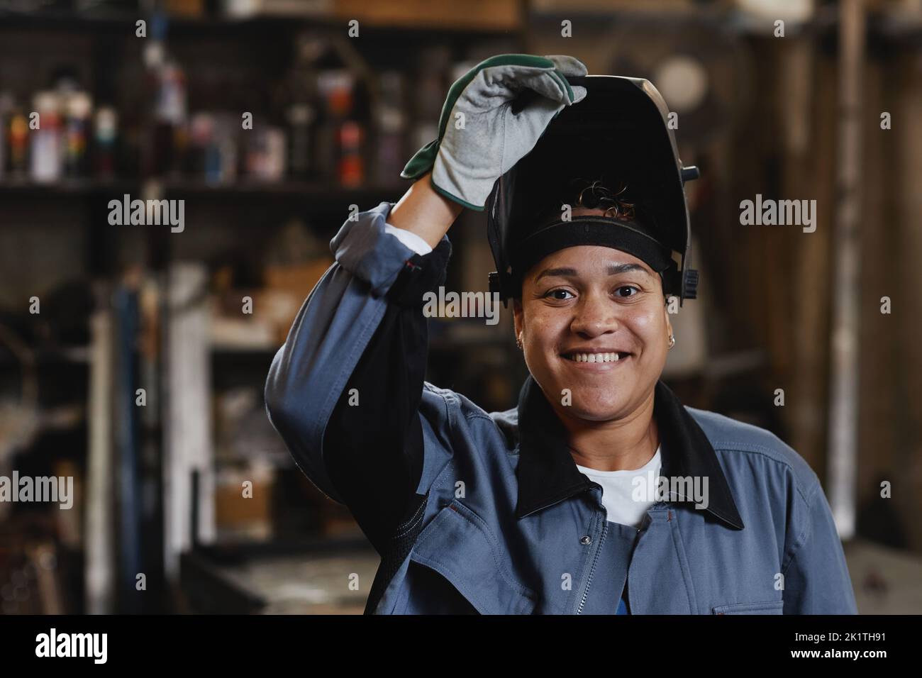 Closeup portrait of smiling female welder looking at camera in ...