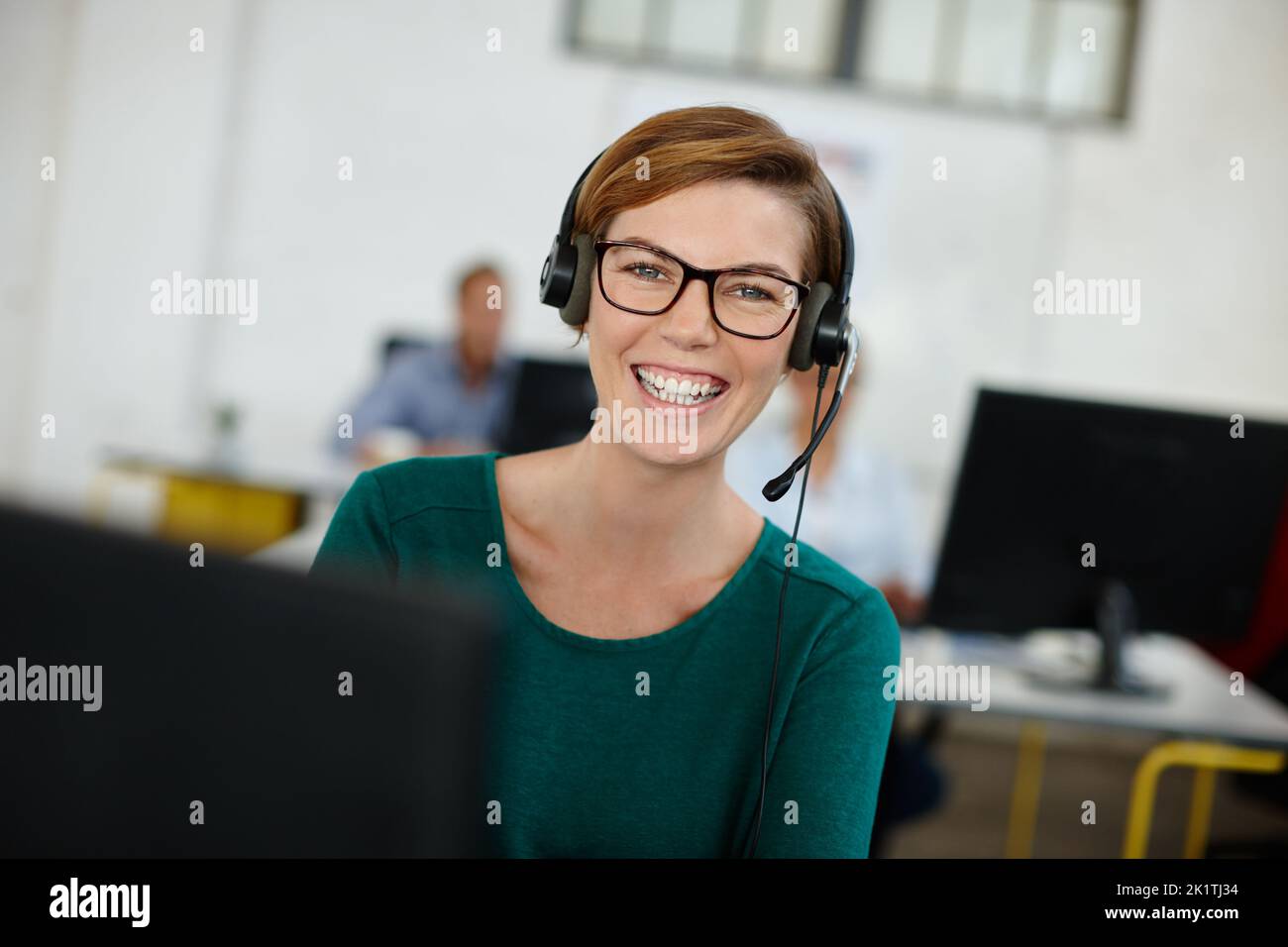 Lets get creative. a beautiful woman wearing a headset while working at ...