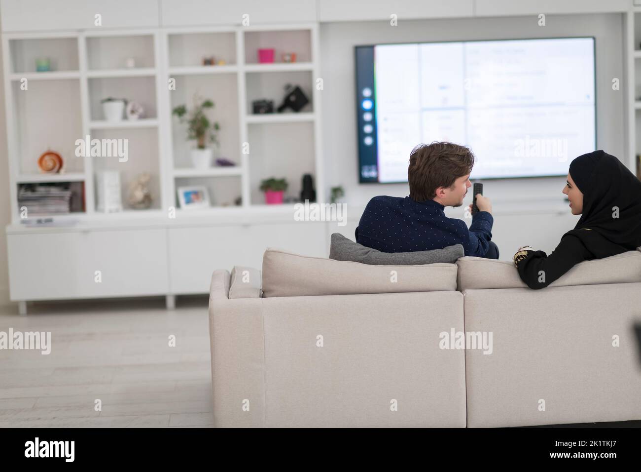 Young muslim couple woman wearing islamic hijab clothes sitting on sofa ...