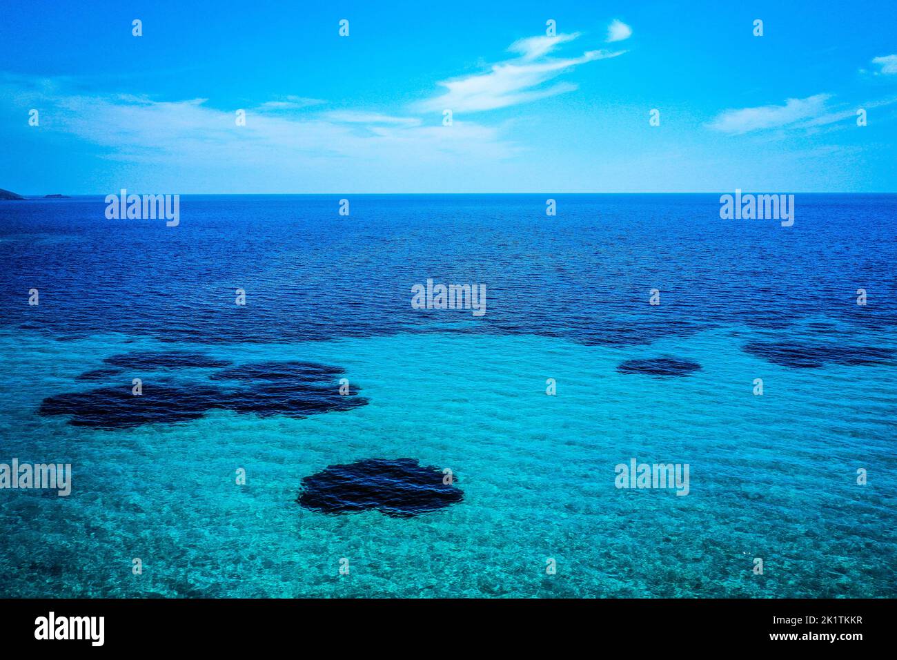 The blue sky over turquoise and blue sea water merging into horizon ...