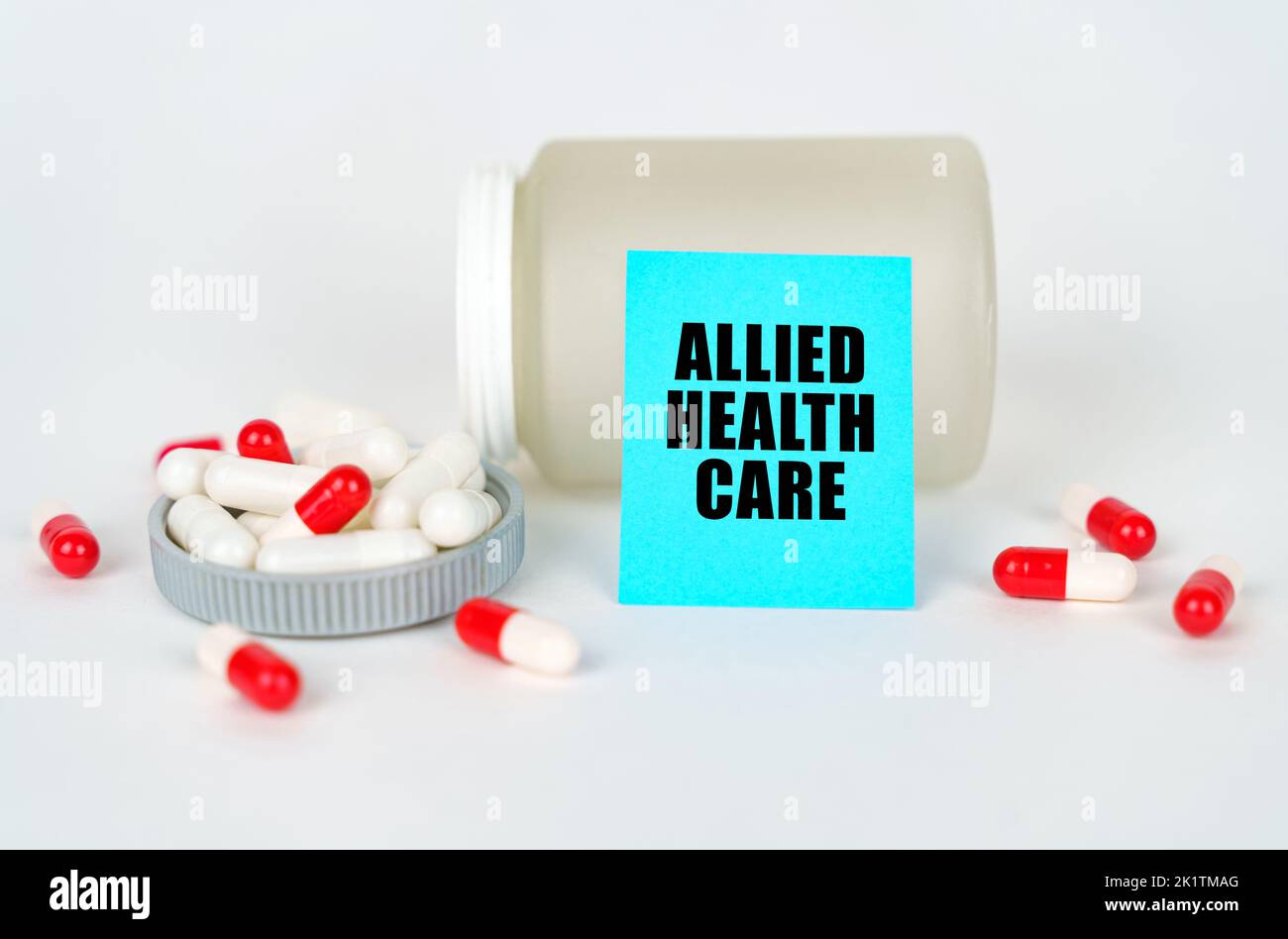Medical concept. On a gray background, a jar, capsules and a sign with ...
