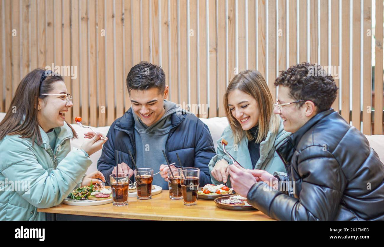 Group of teenagers having fun drinking and having brunch outdoors ...