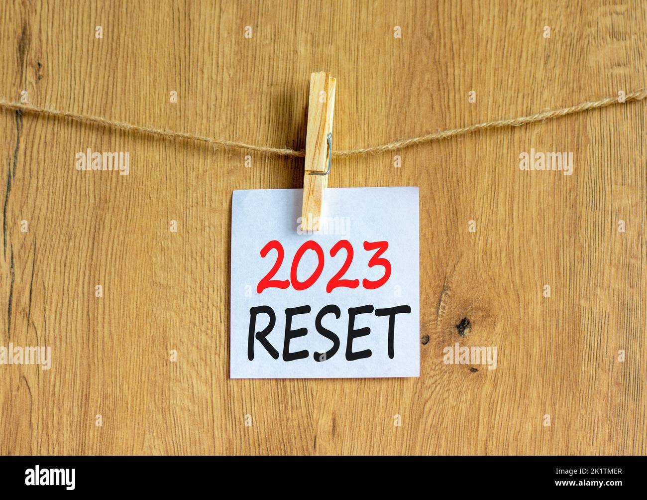 2023 Reset symbol. White paper with words 2023 Reset, clip on wooden ...
