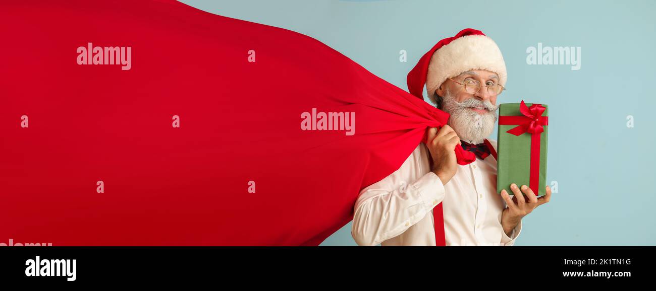 Santa Claus with gift and bag on light blue background. Banner for ...