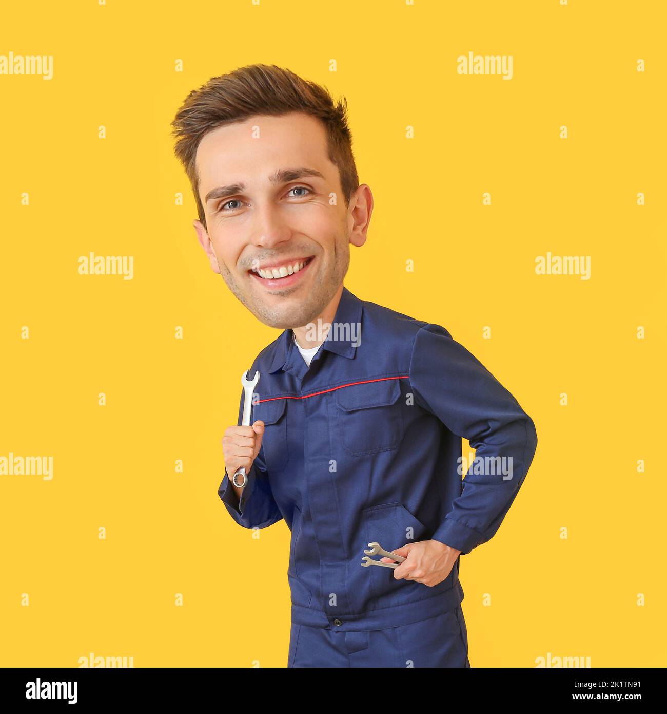 Funny car mechanic with big head on yellow background Stock Photo - Alamy