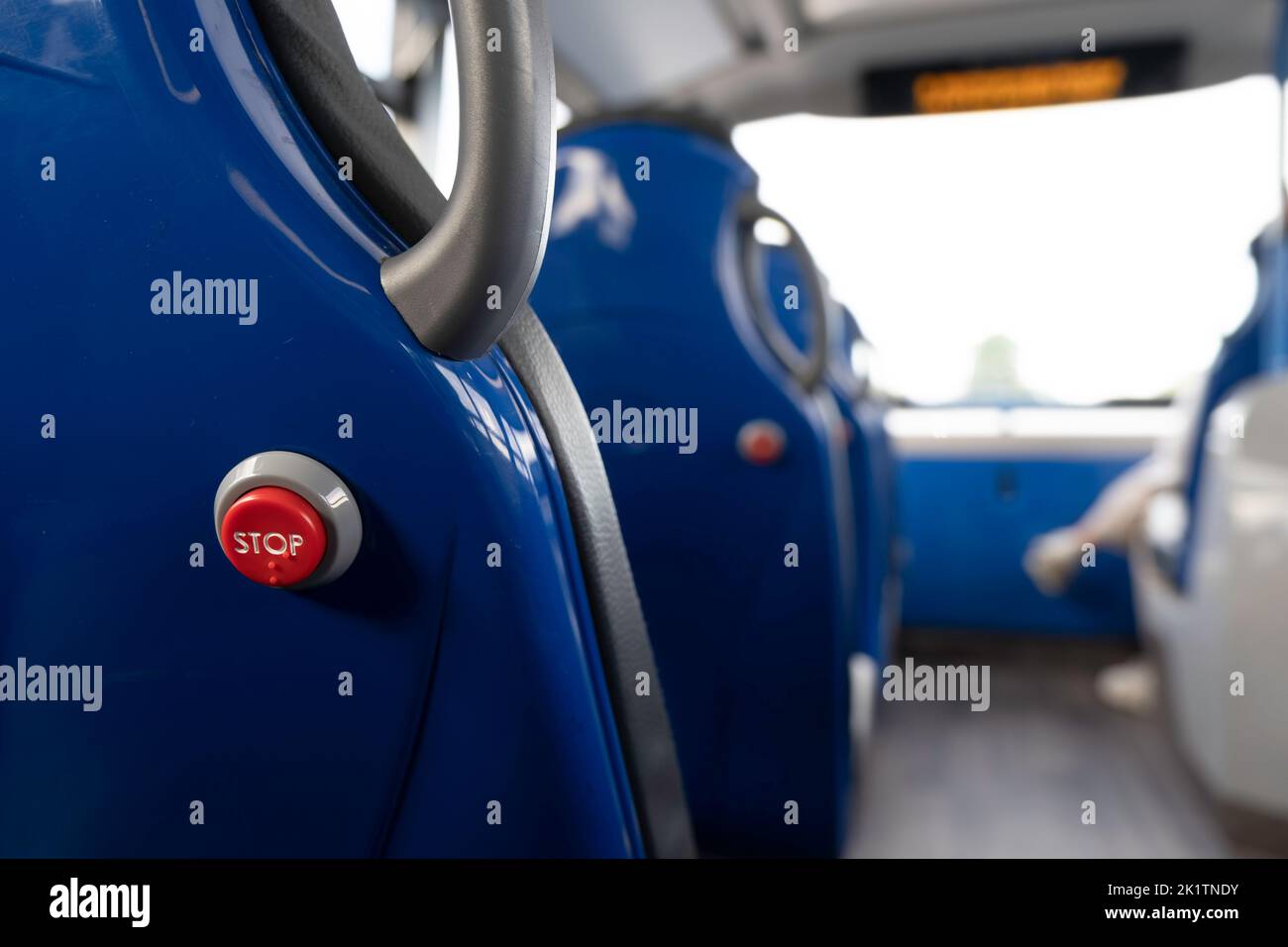 Red bus stop button to get off in the back of a seat in a double-decker ...