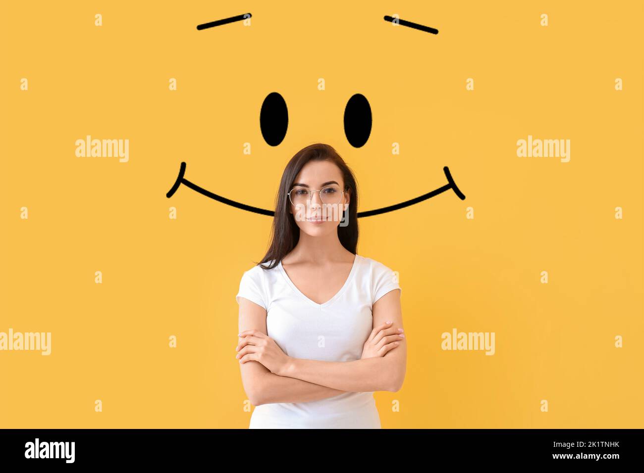 Beautiful young woman and drawn smile on yellow background Stock Photo ...