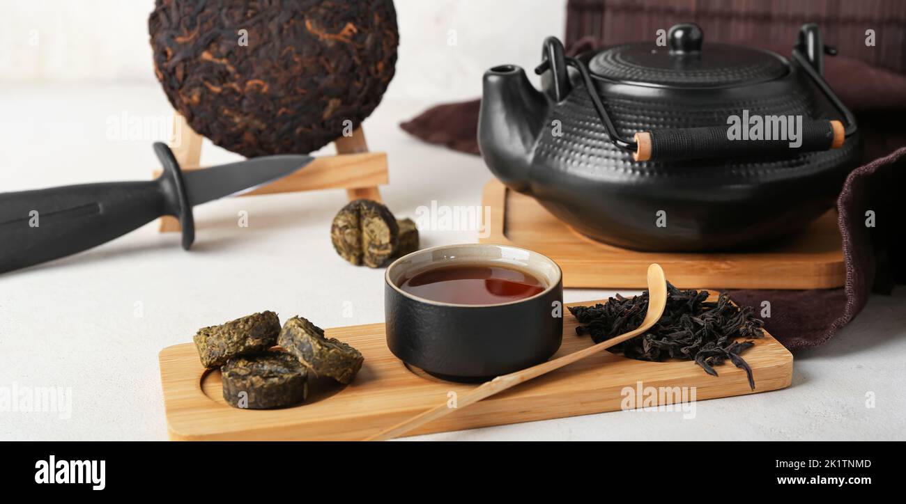 Cup of hot puer tea and teapot on white table Stock Photo - Alamy