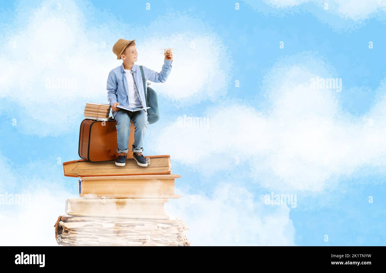 Cute little adventurer with luggage and toy airplane sitting on stack ...