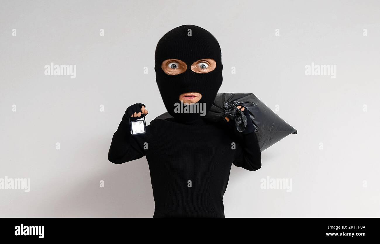Funny thief with big head on light background Stock Photo - Alamy