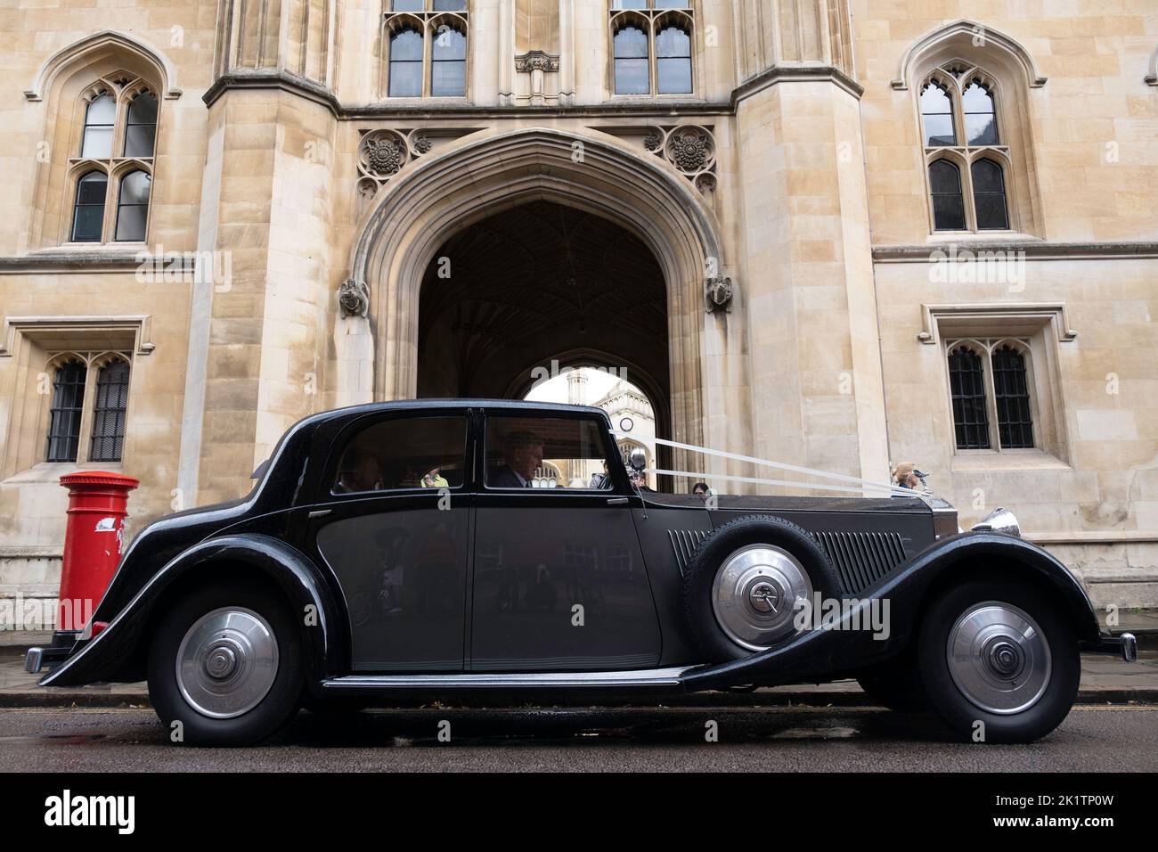 Driver waits in an old-fashioned luxurious and stately black car for ...