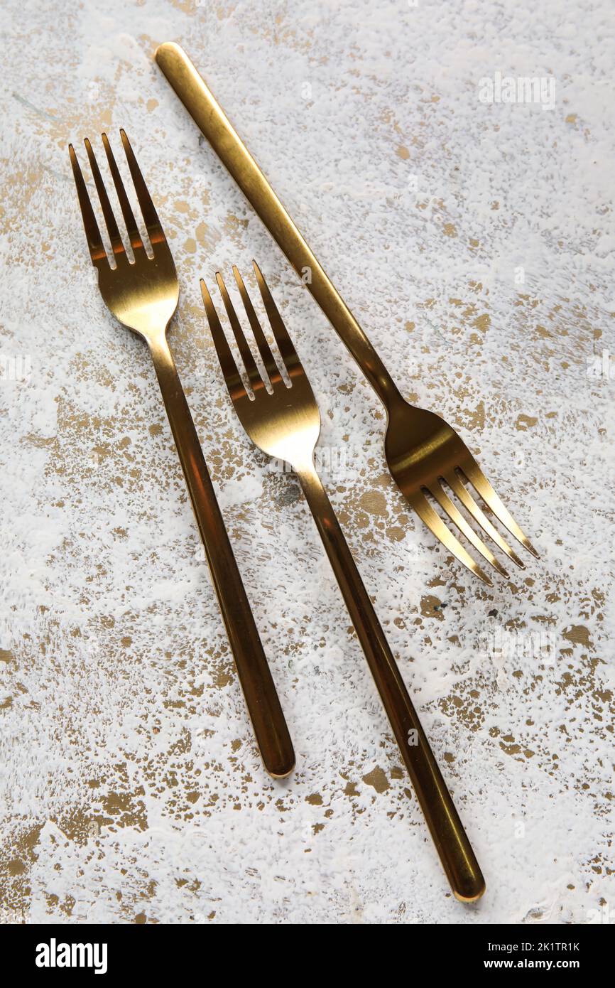 Golden forks on grunge background Stock Photo - Alamy