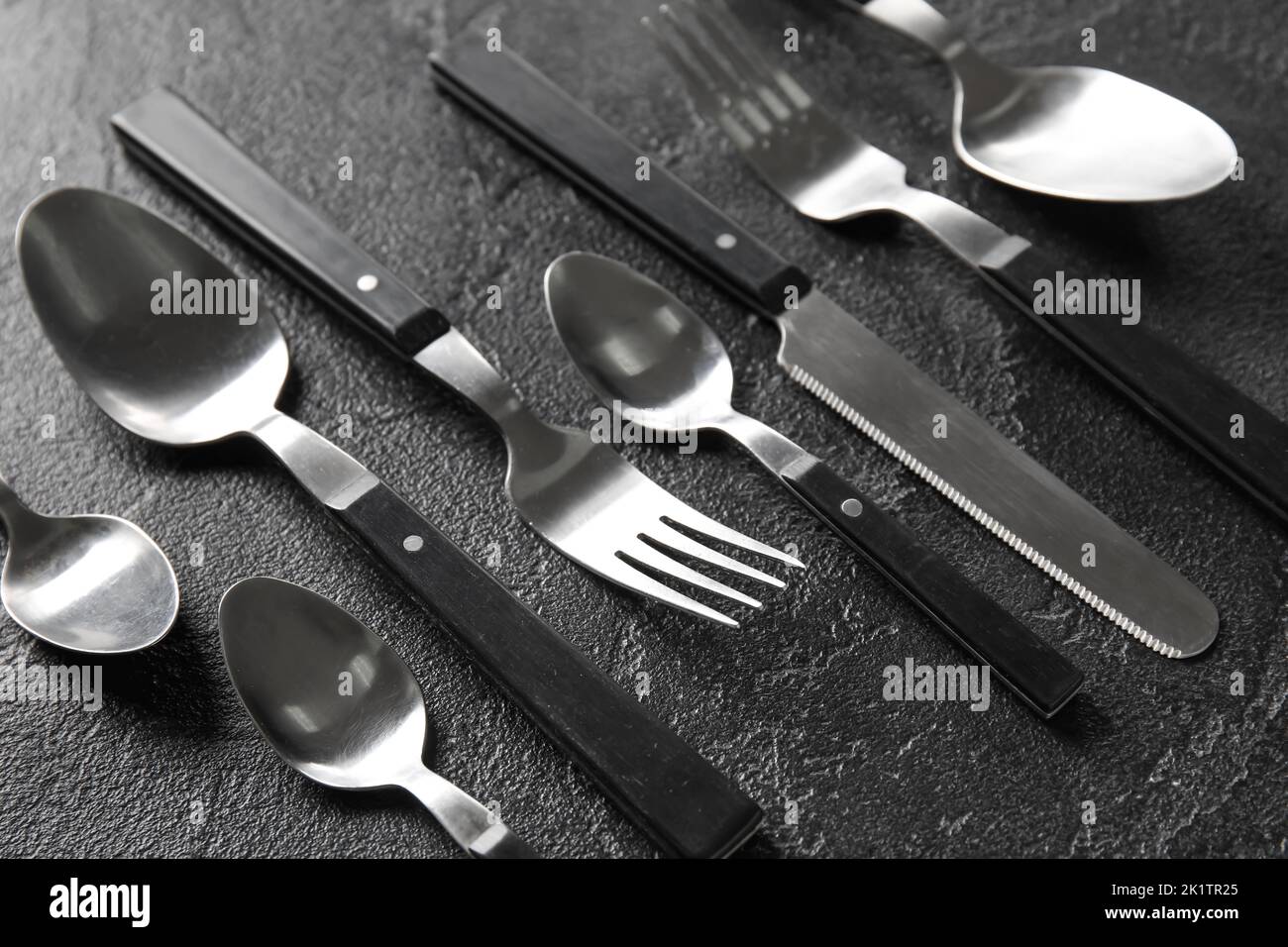 Different cutlery on dark background Stock Photo - Alamy
