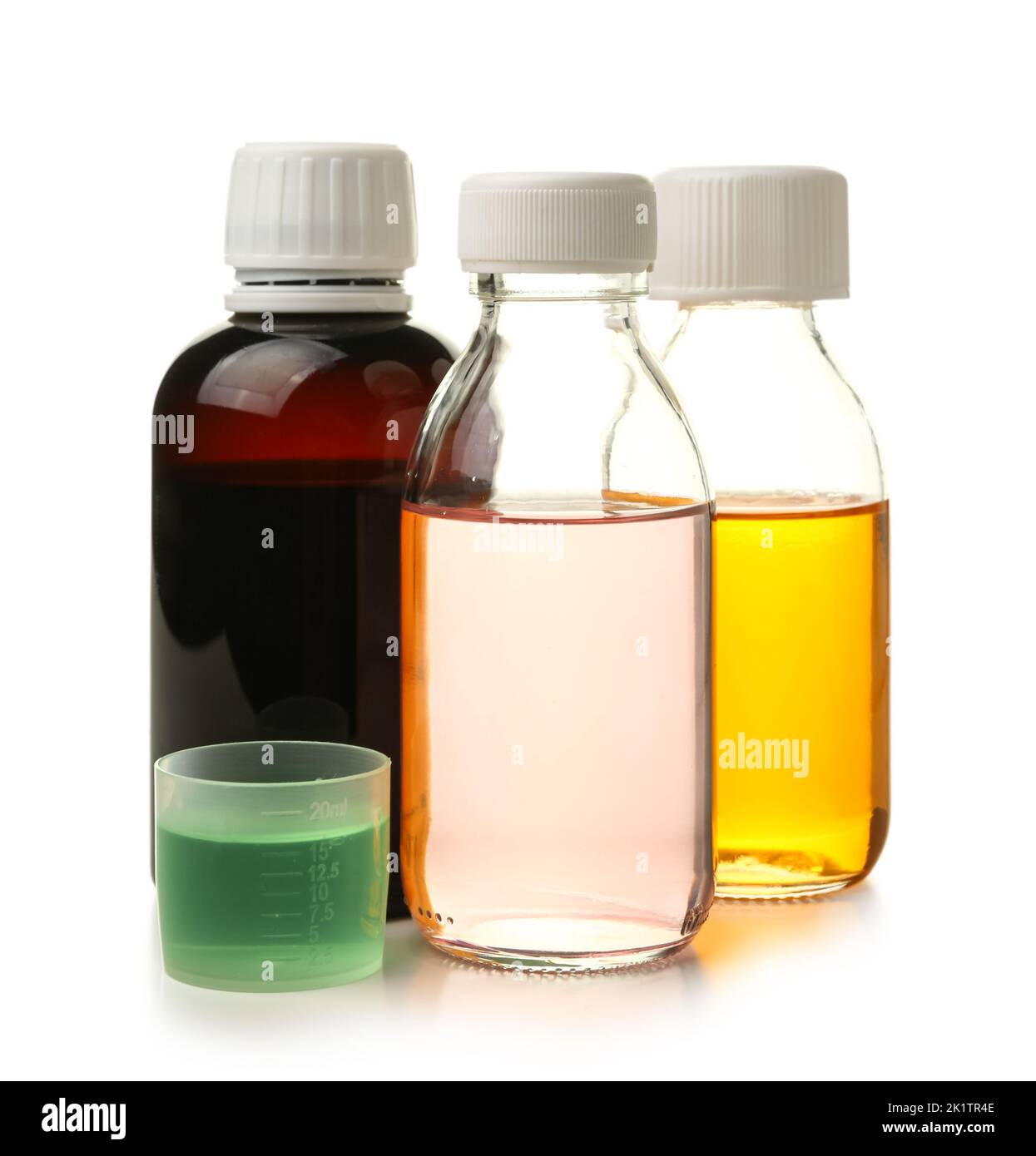 Bottles of cough syrup and cup on white background Stock Photo - Alamy