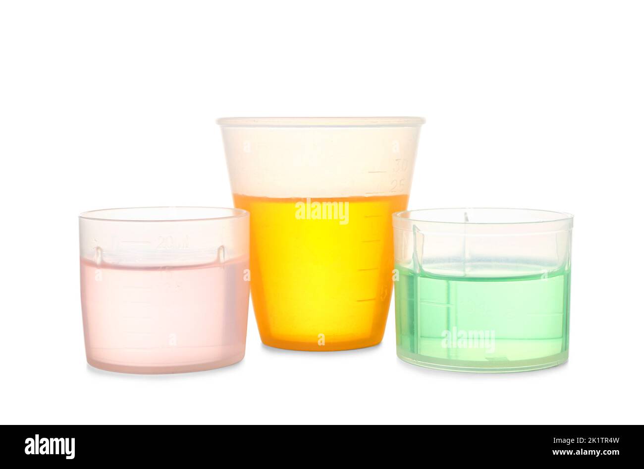 Measuring cups of cough syrup on white background Stock Photo - Alamy