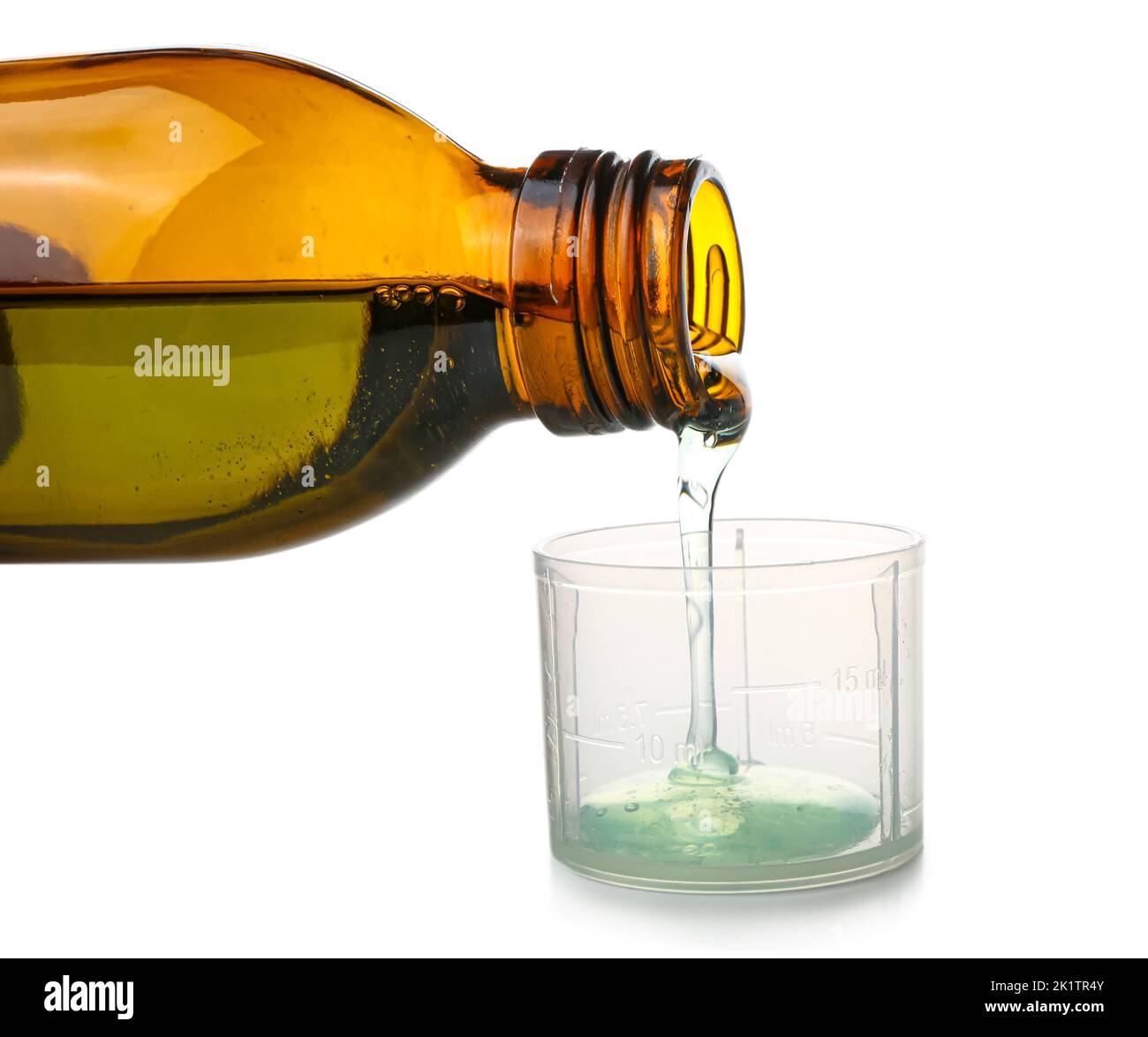Pouring of cough syrup from bottle into cup on white background Stock ...