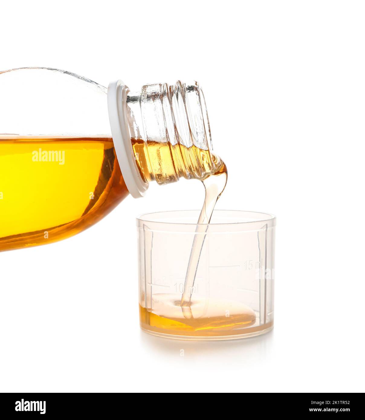 Pouring of cough syrup from bottle into cup on white background Stock ...