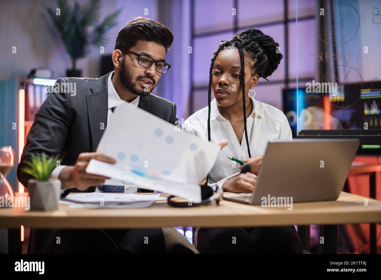 Two multicultural company workers arab financial expert and african woman office worker using ...