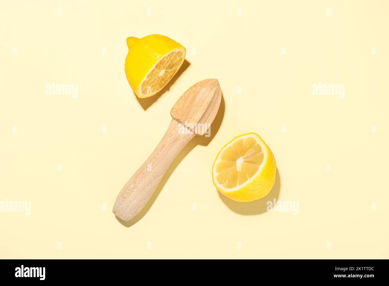 Cut ripe lemon and wooden juicer on color background Stock Photo - Alamy