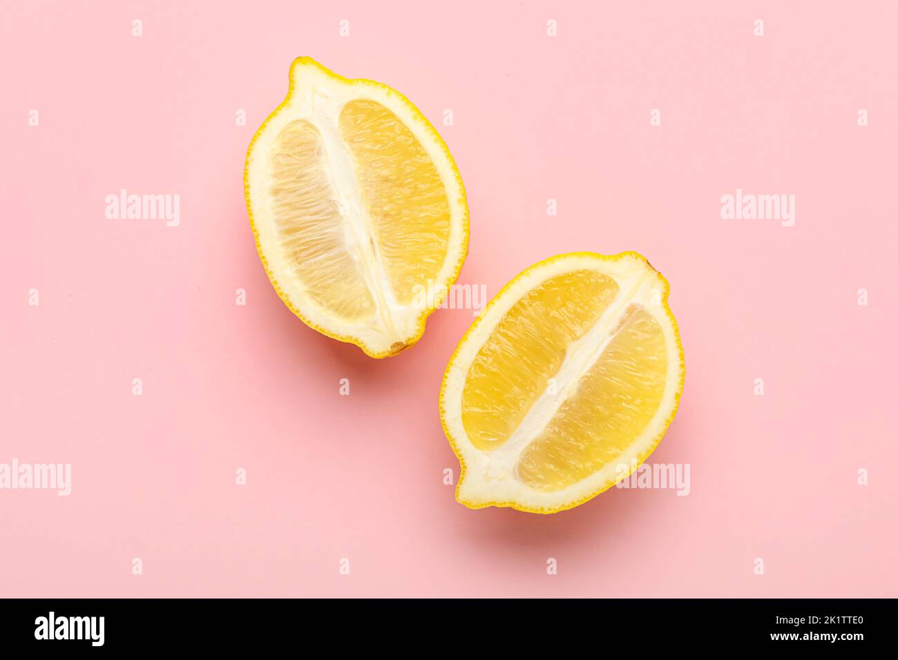 Halves of fresh lemon on pink background Stock Photo - Alamy
