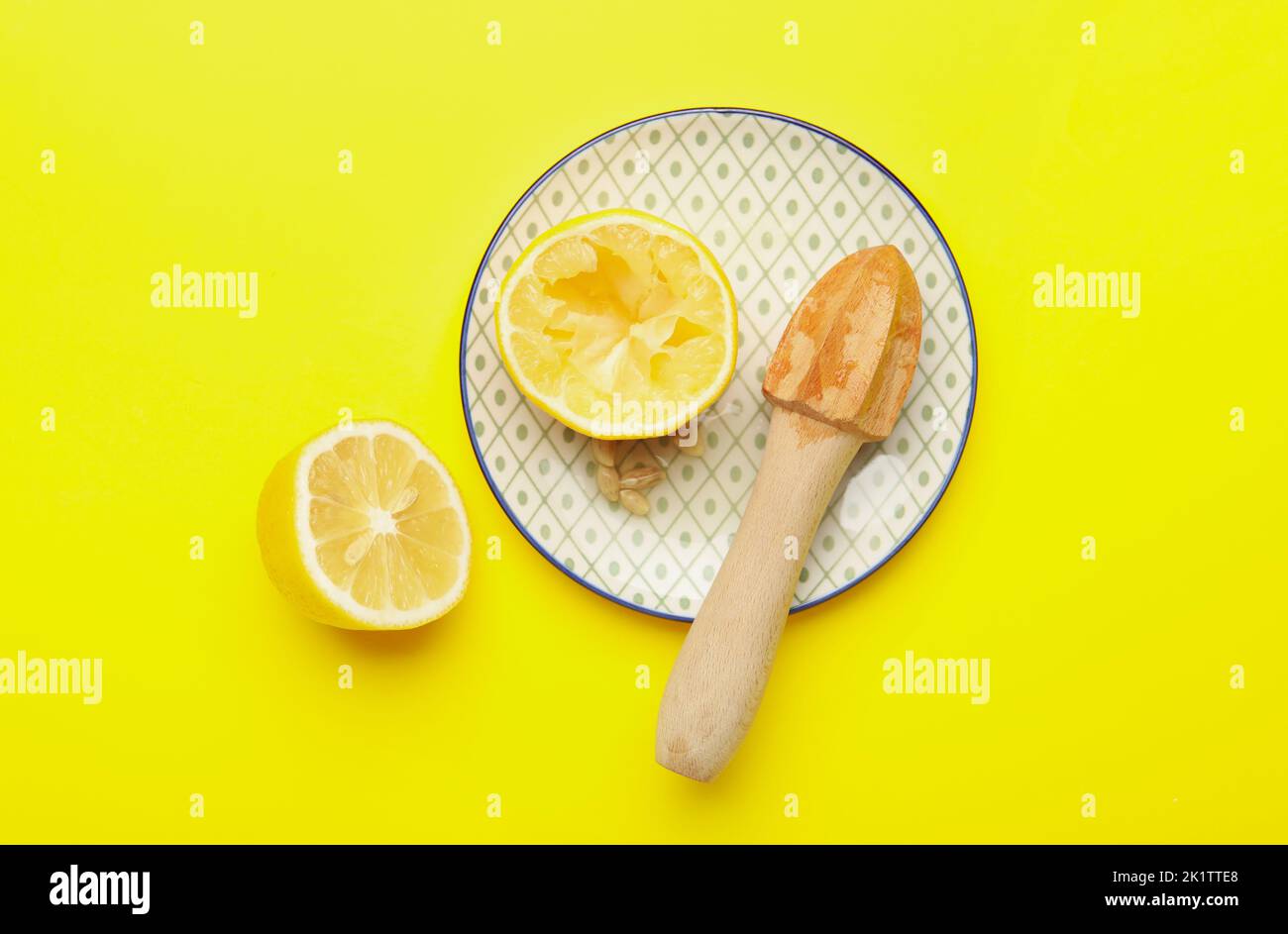 Plate with fresh lemon and wooden juicer on yellow background Stock ...
