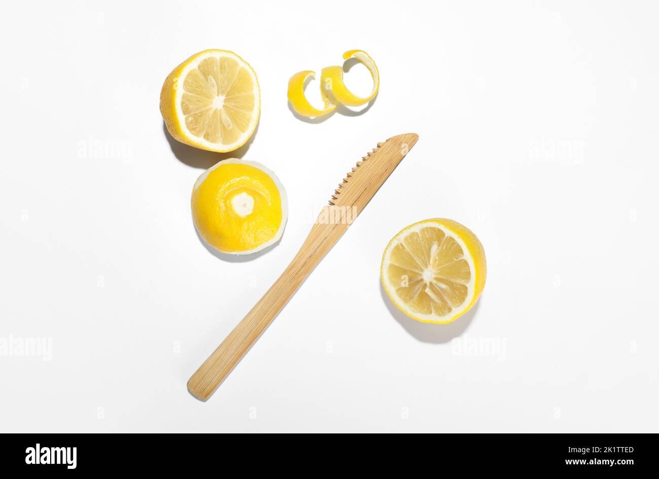 Fresh cut lemons and wooden knife on white background Stock Photo - Alamy