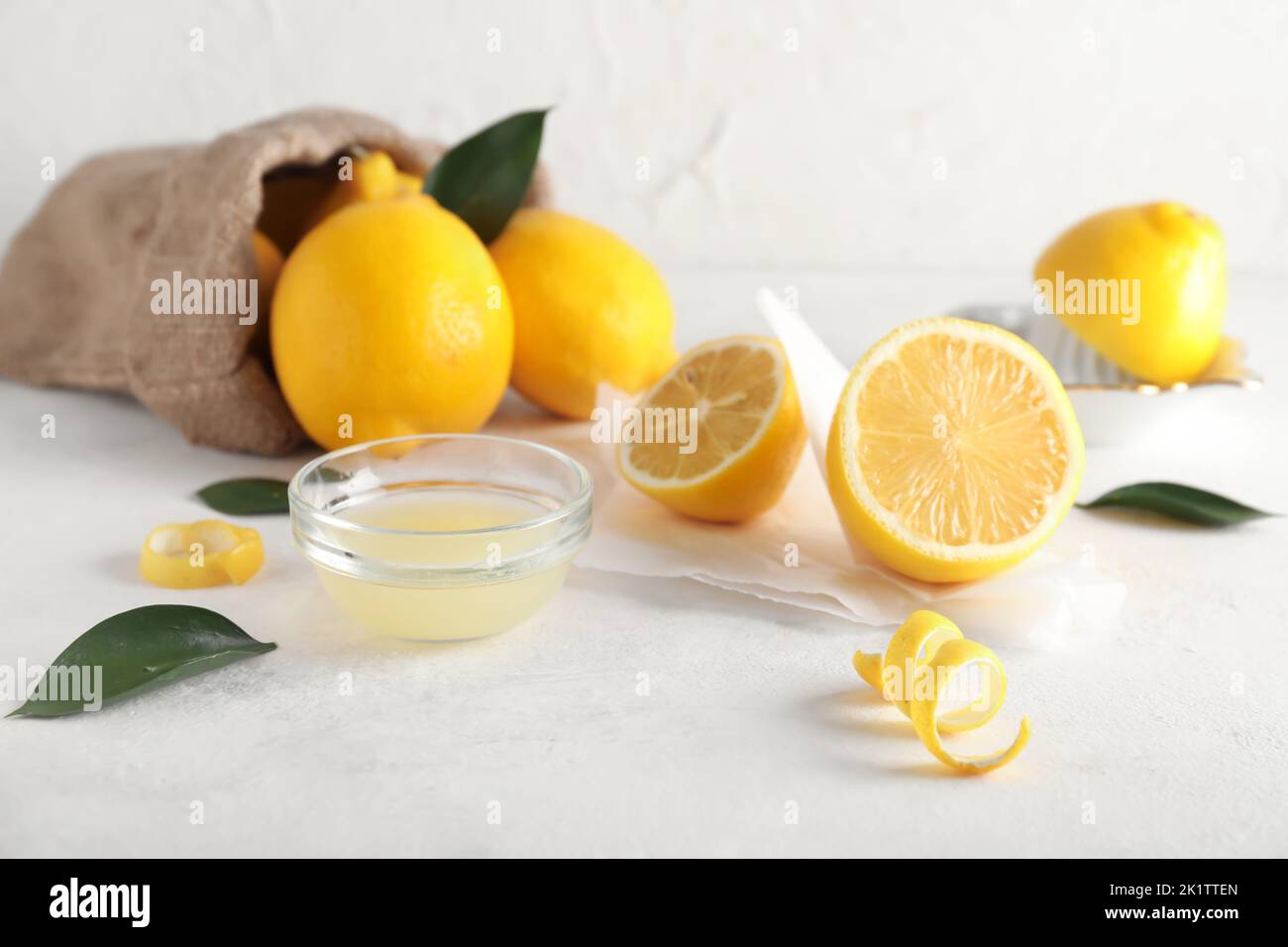 Fresh lemons and bowl of juice on light background Stock Photo - Alamy