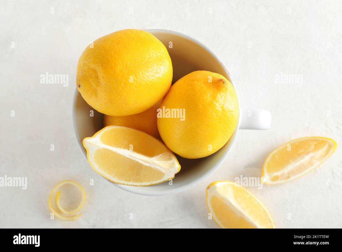 Cup of fresh lemons on light background Stock Photo - Alamy