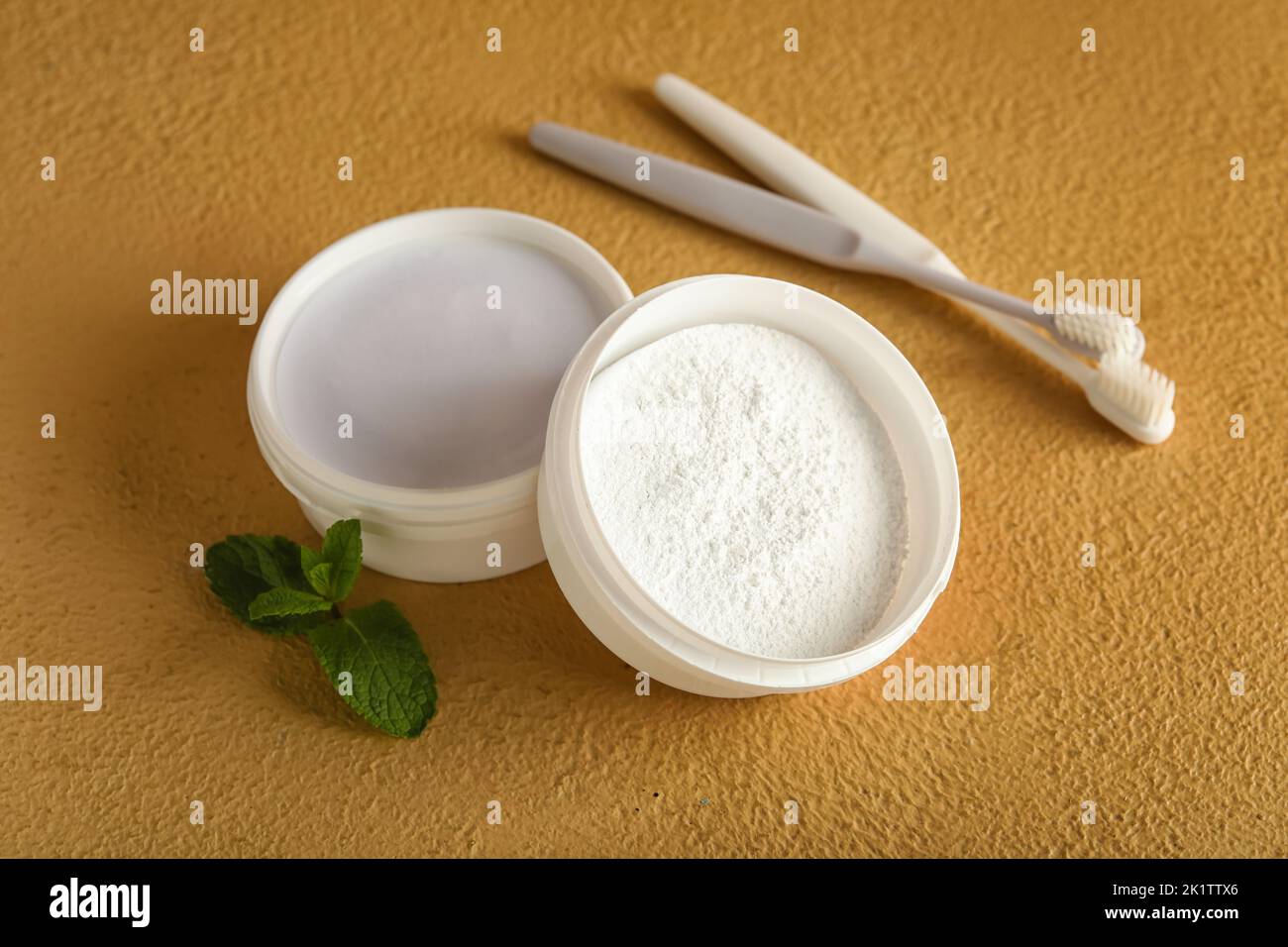 Jars of tooth powder with brushes and mint on beige background Stock ...