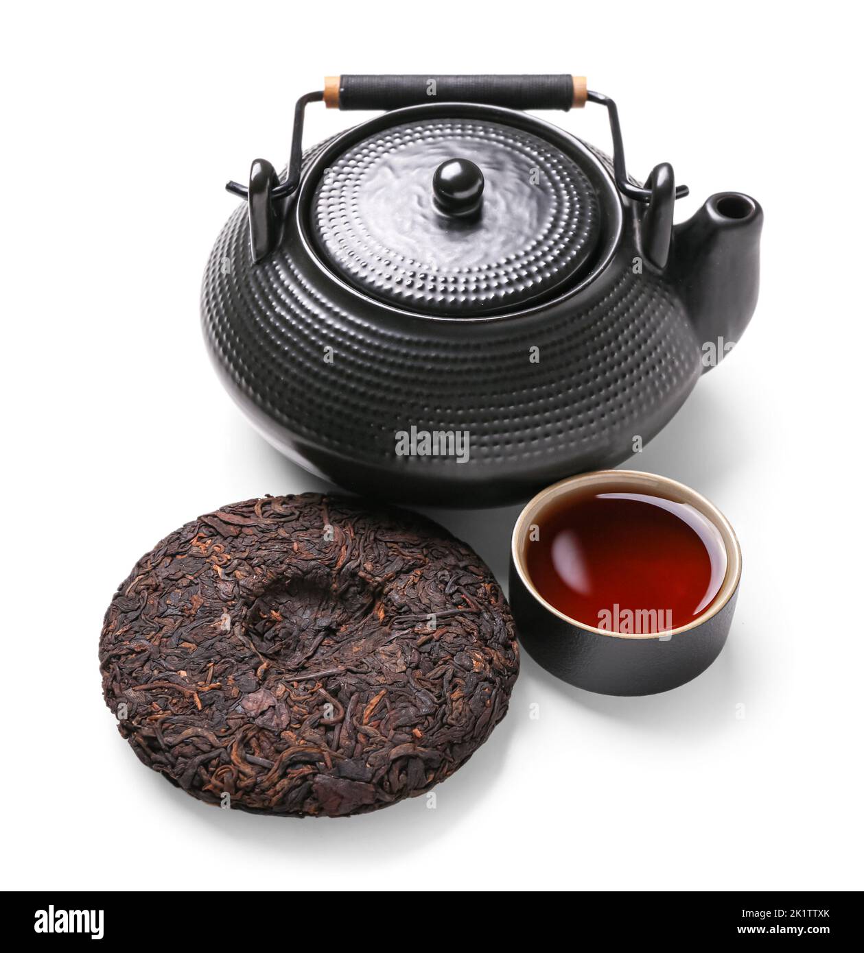 Dry pressed puer tea with cup and teapot on white background Stock ...