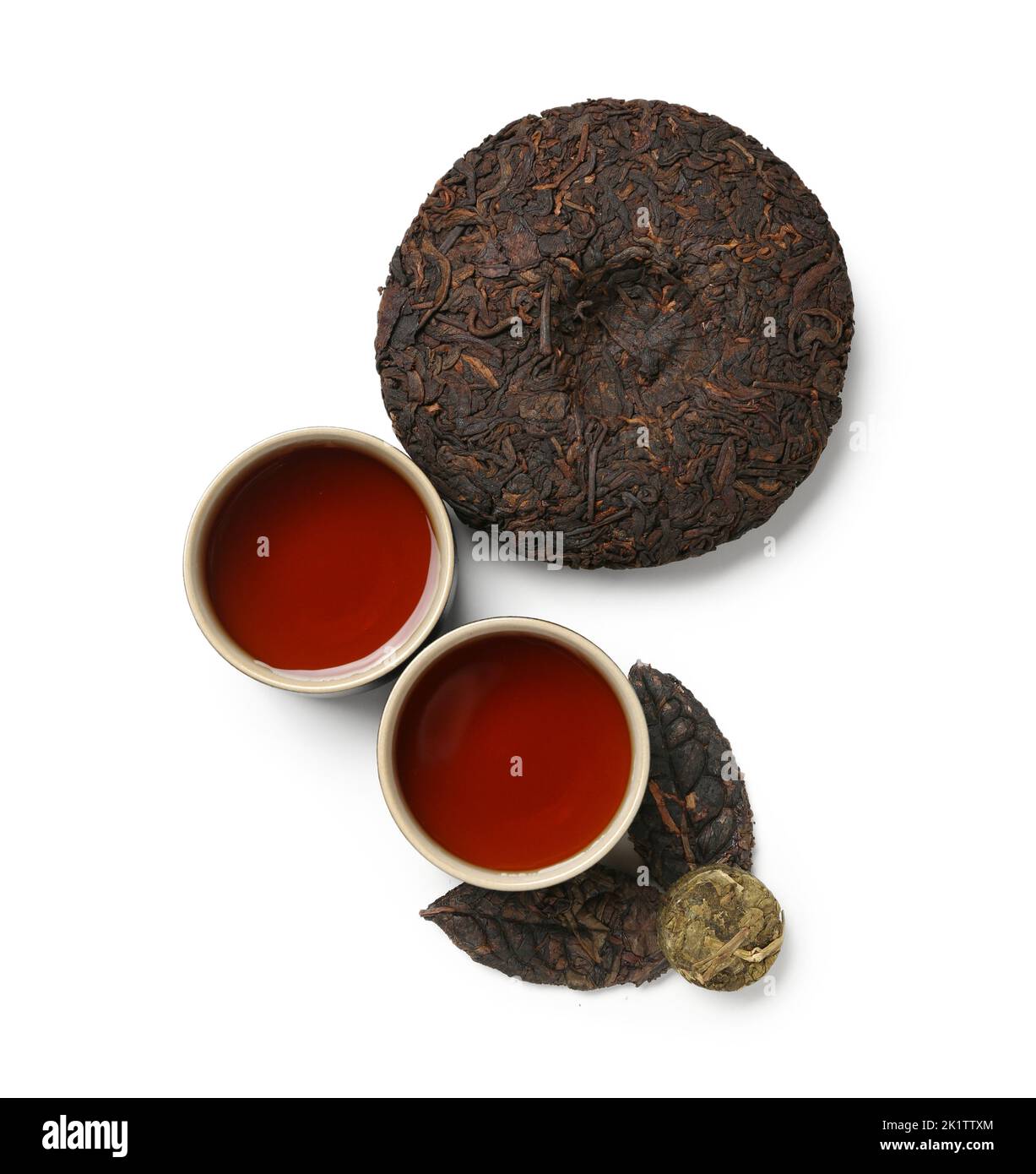 Dry pressed puer tea with cups on white background Stock Photo - Alamy