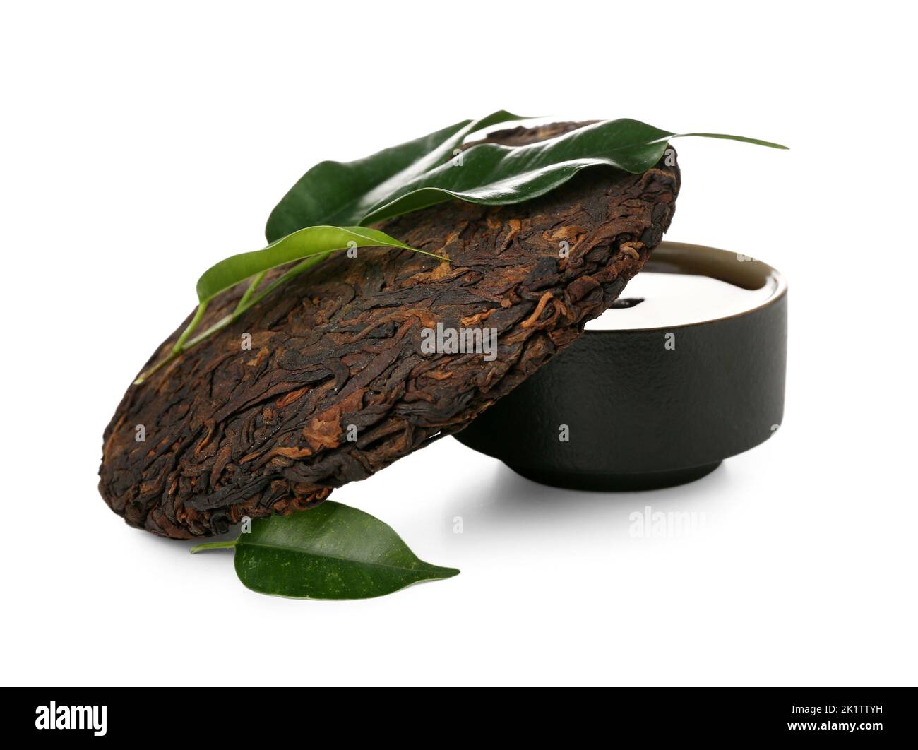 Dry pressed puer tea with cup and leaves on white background Stock ...
