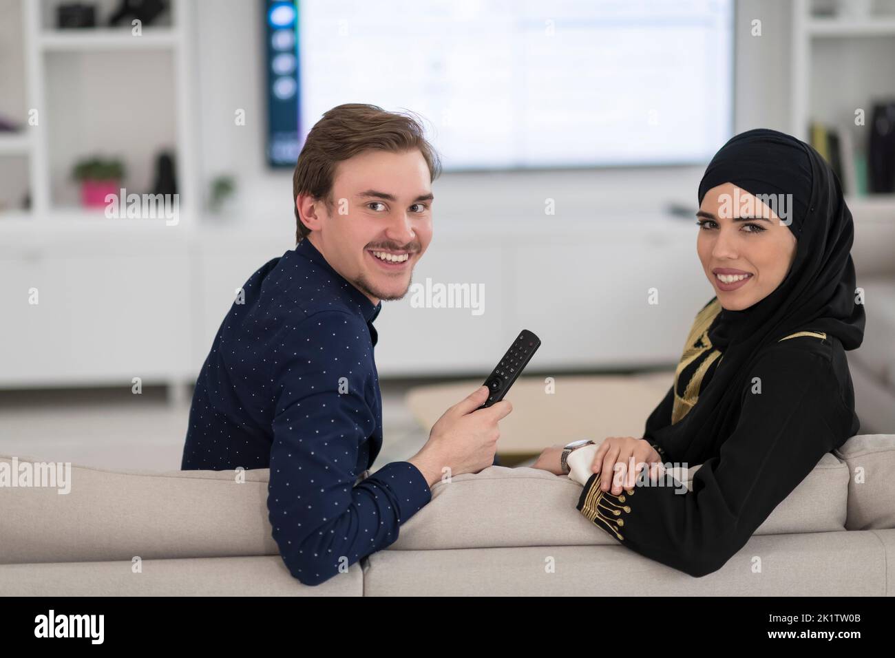 Young muslim couple woman wearing islamic hijab clothes sitting on sofa ...