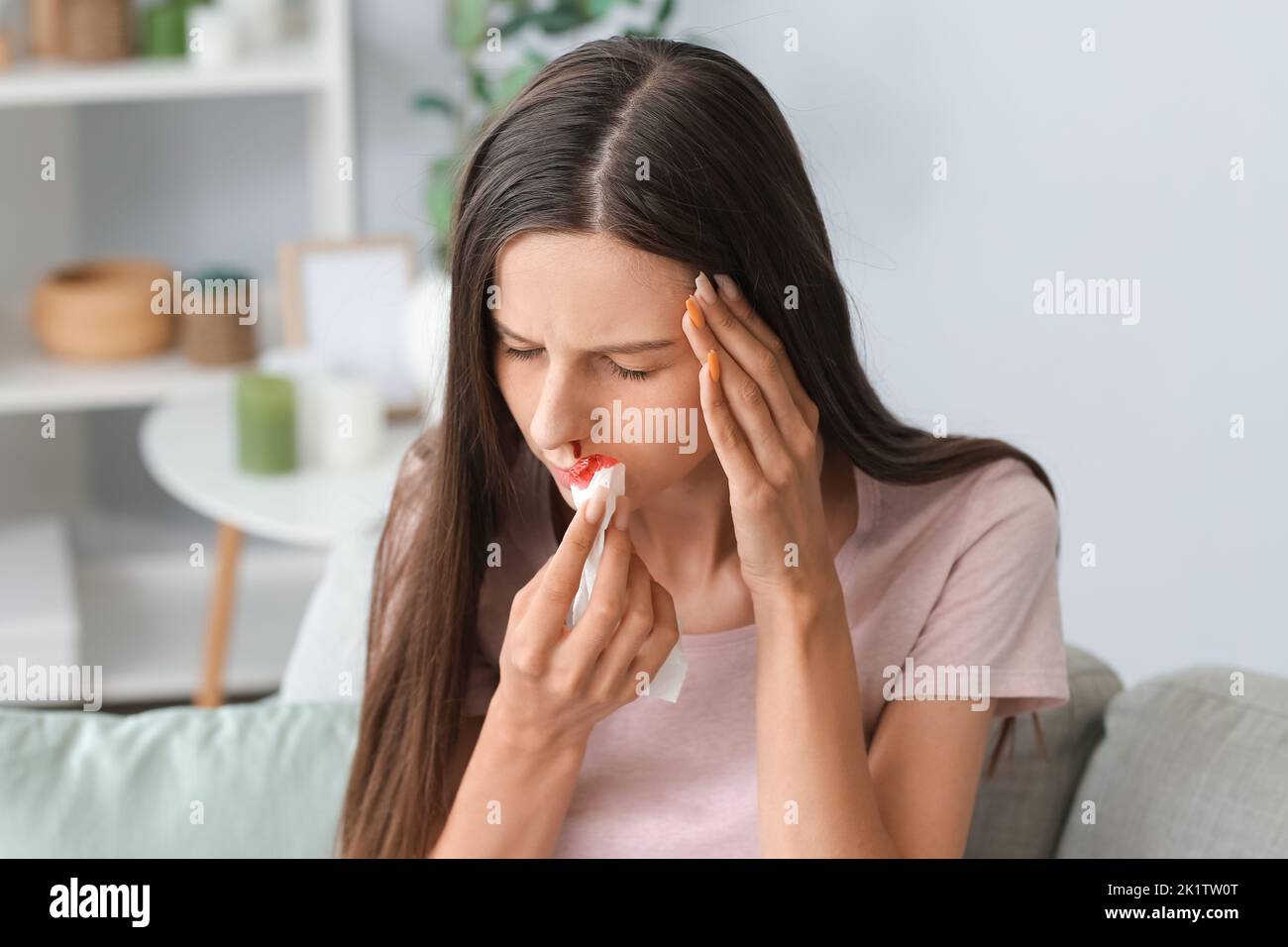Young woman wiping nosebleed with tissue at home, closeup Stock Photo ...