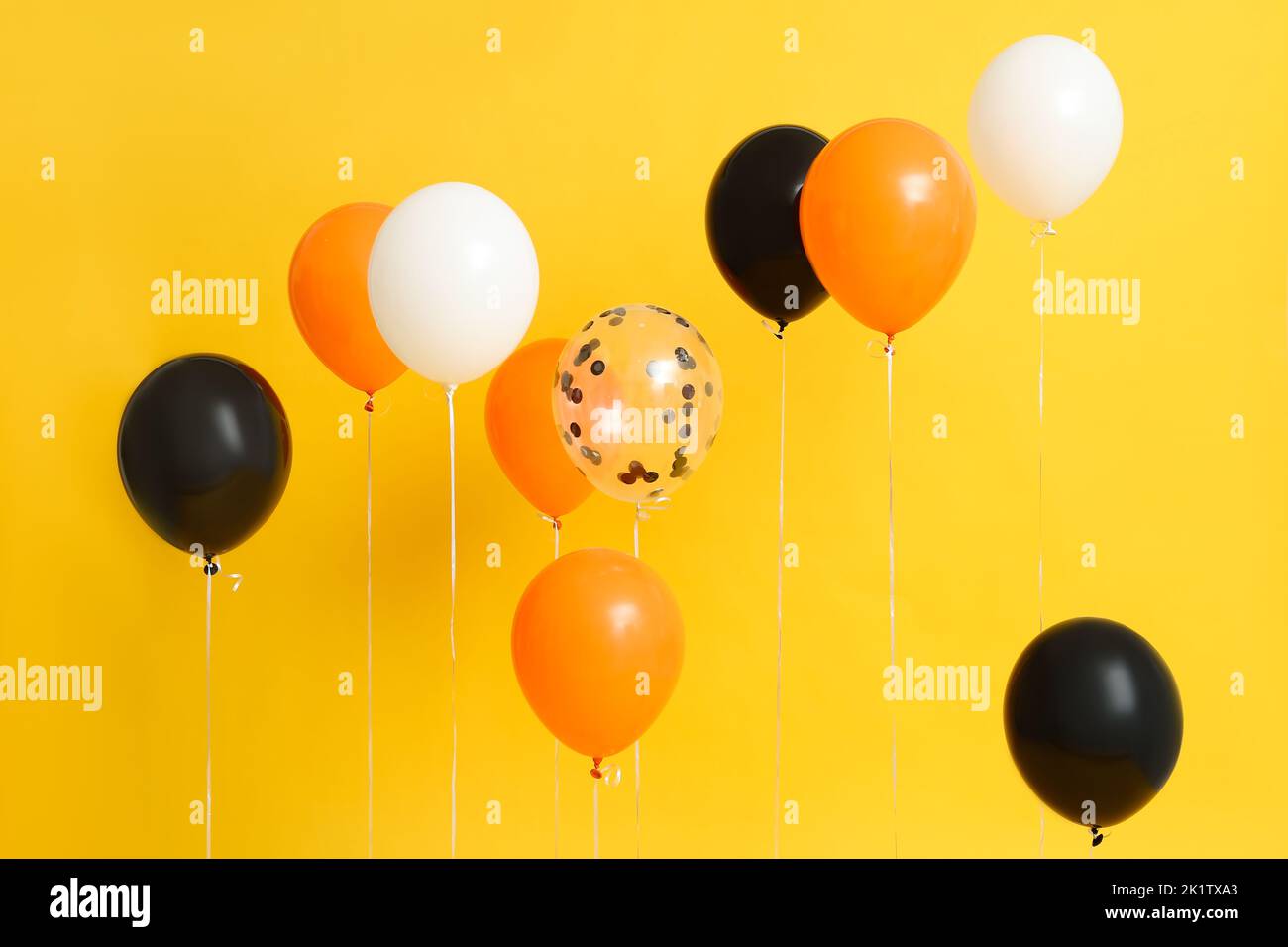 Halloween balloons on yellow background Stock Photo - Alamy