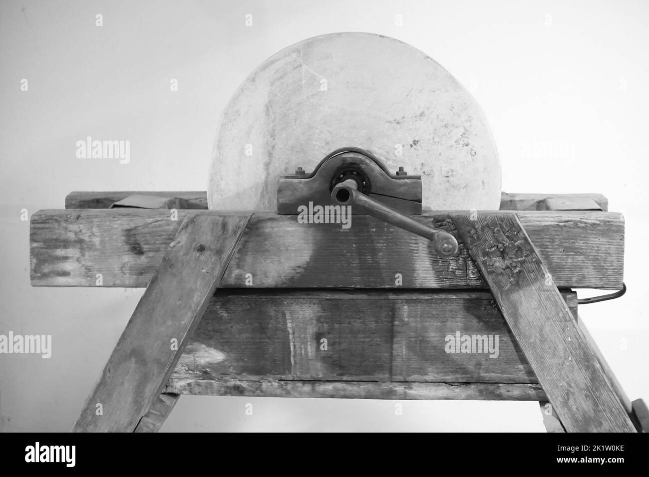 A black and white shot of an old rustic stonecutter isolated on a white ...