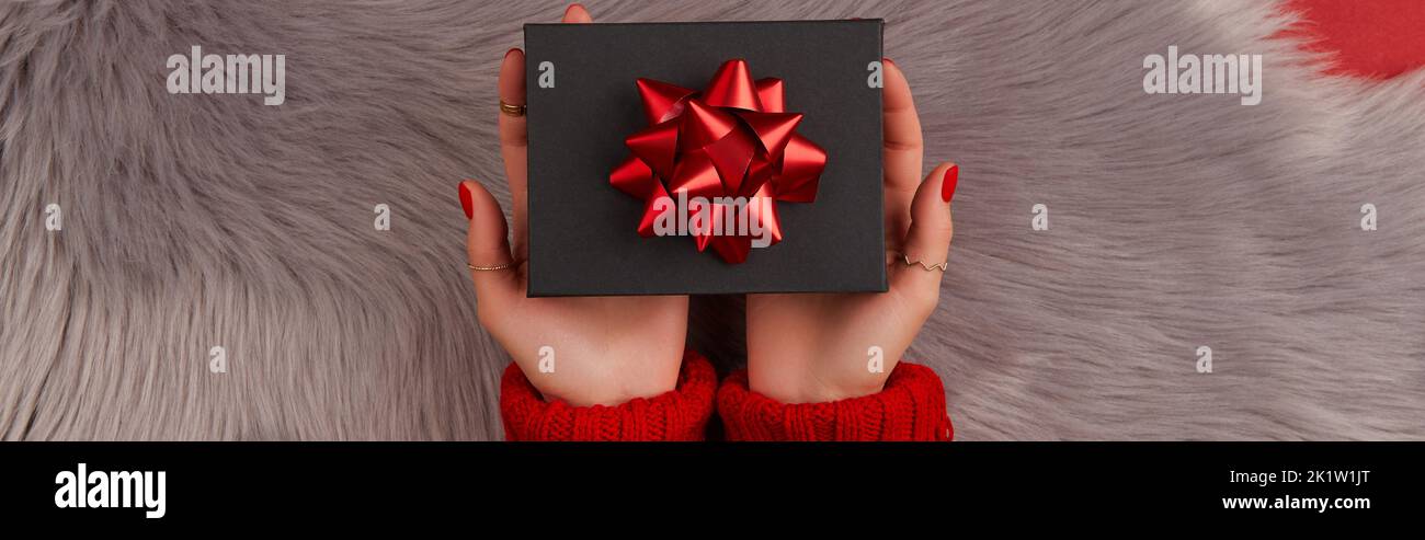 Manicured womans hands holding gift box on furry background Stock Photo ...