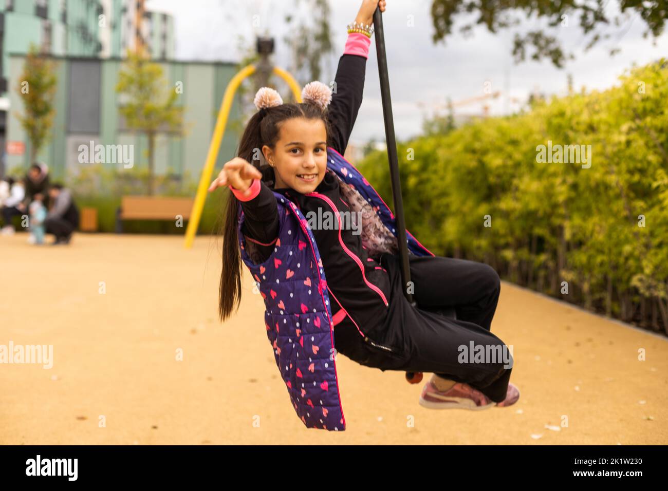 Little girl rides on Flying Fox play equipment. Child girl is smiling ...