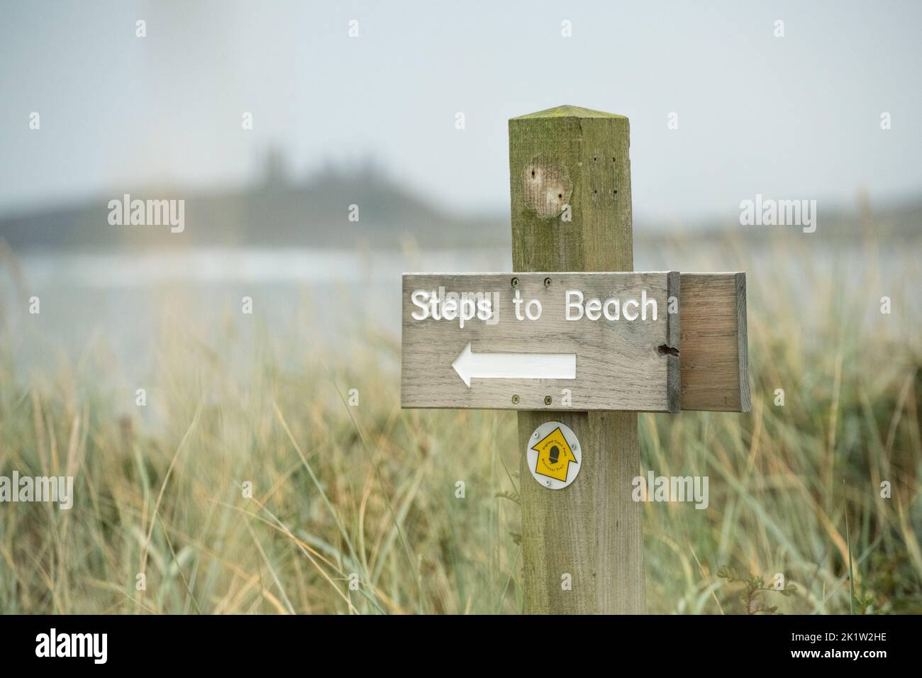 Wooden sign pointing to the beach at Embleton, Northumberland, England ...