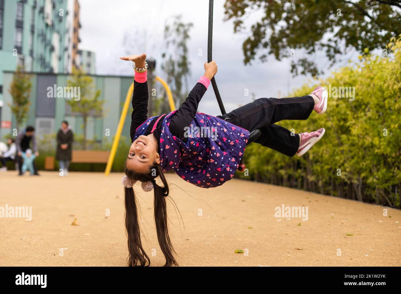 Little girl rides on Flying Fox play equipment. Child girl is smiling ...